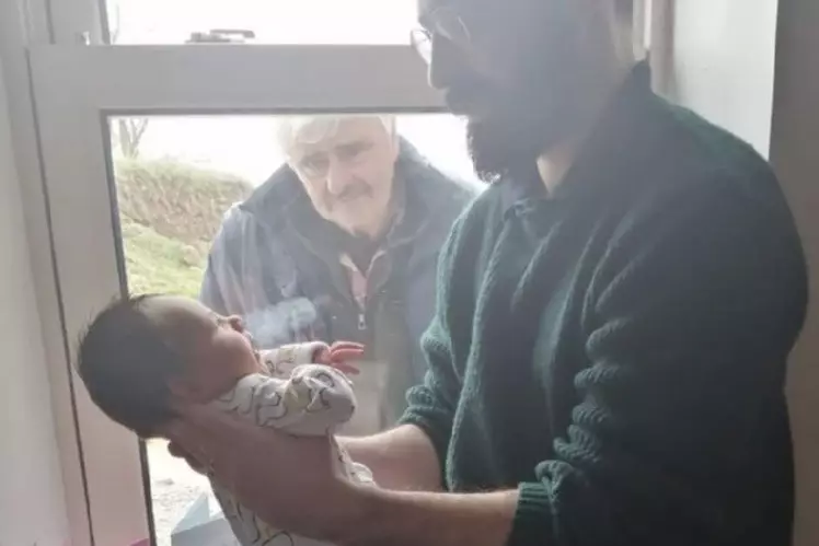 一位祖父在冠状病毒时期遇见他刚出生的孙子的感人照片