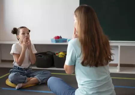 Psychologist Helping Girl In Speech Therapy