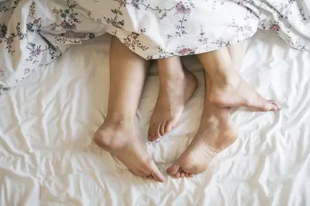 Nohy páru v posteli