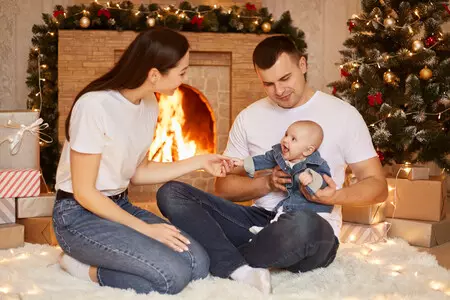 Retrato de família feliz pai mãe e filha da criança posando na lareira e árvore de Natal em casa sendo feliz para celebrar as férias de inverno juntos feliz ano novo