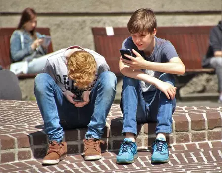 Two boys looking at their phones