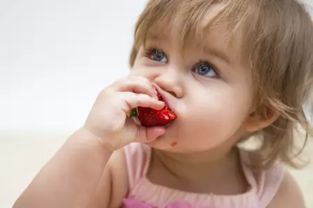 Девојка једе црвено воће